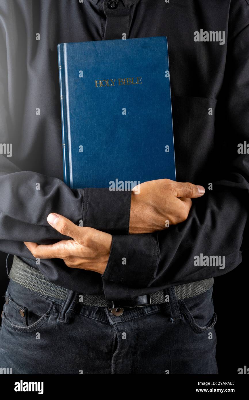 Man holding a holy bible in his hand. Symbol of faith and worship in ...