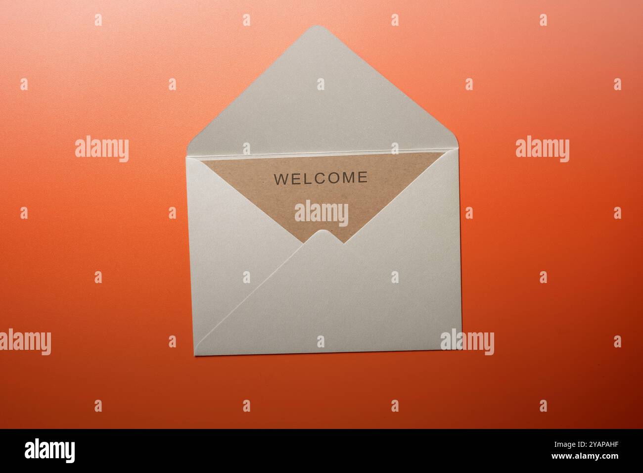 Top view of white envelope and postcard with brown card with words ...