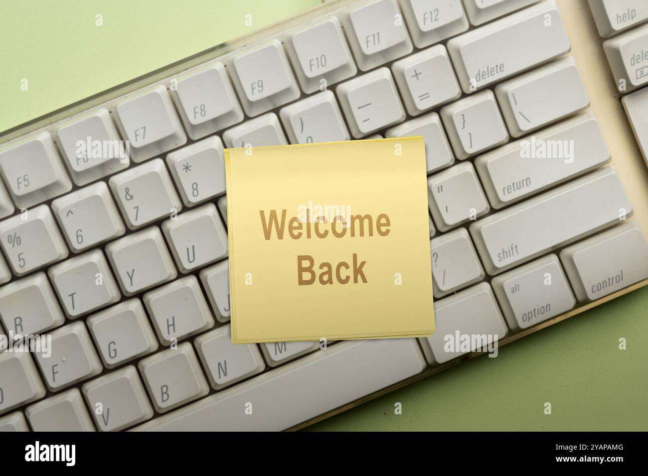 Yellow note showing word "Welcome back" written on it. Welcome greeting ...