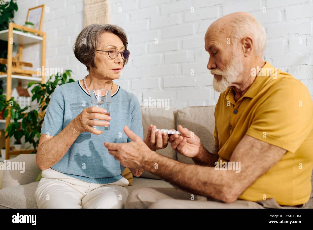 A devoted wife offers her husband a glass of water while he prepares to ...
