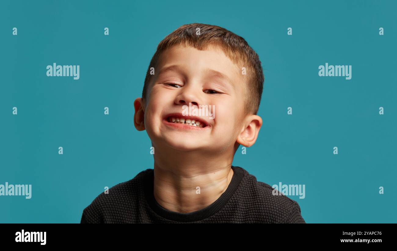 Boy grins widely, showing off his teeth in cheeky smile. His happiness ...