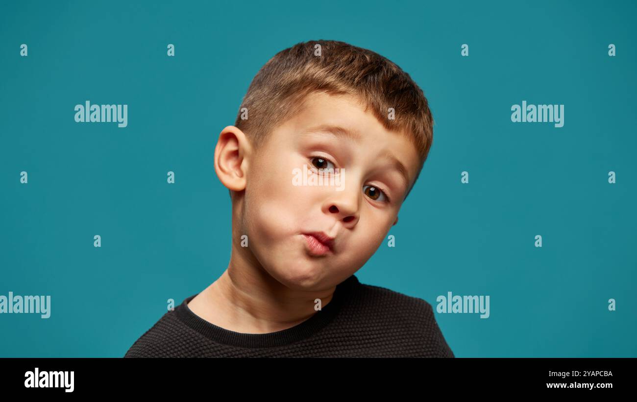 Boy's playful smirk and raised eyebrows show his curiosity. Kid in ...