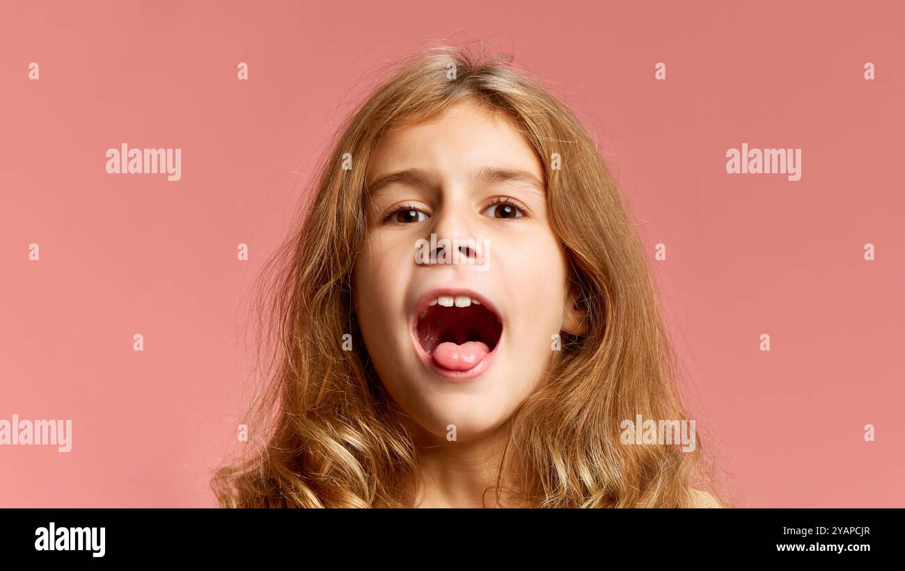 Preschool girl shouting, her mouth wide open in exaggerated expression ...