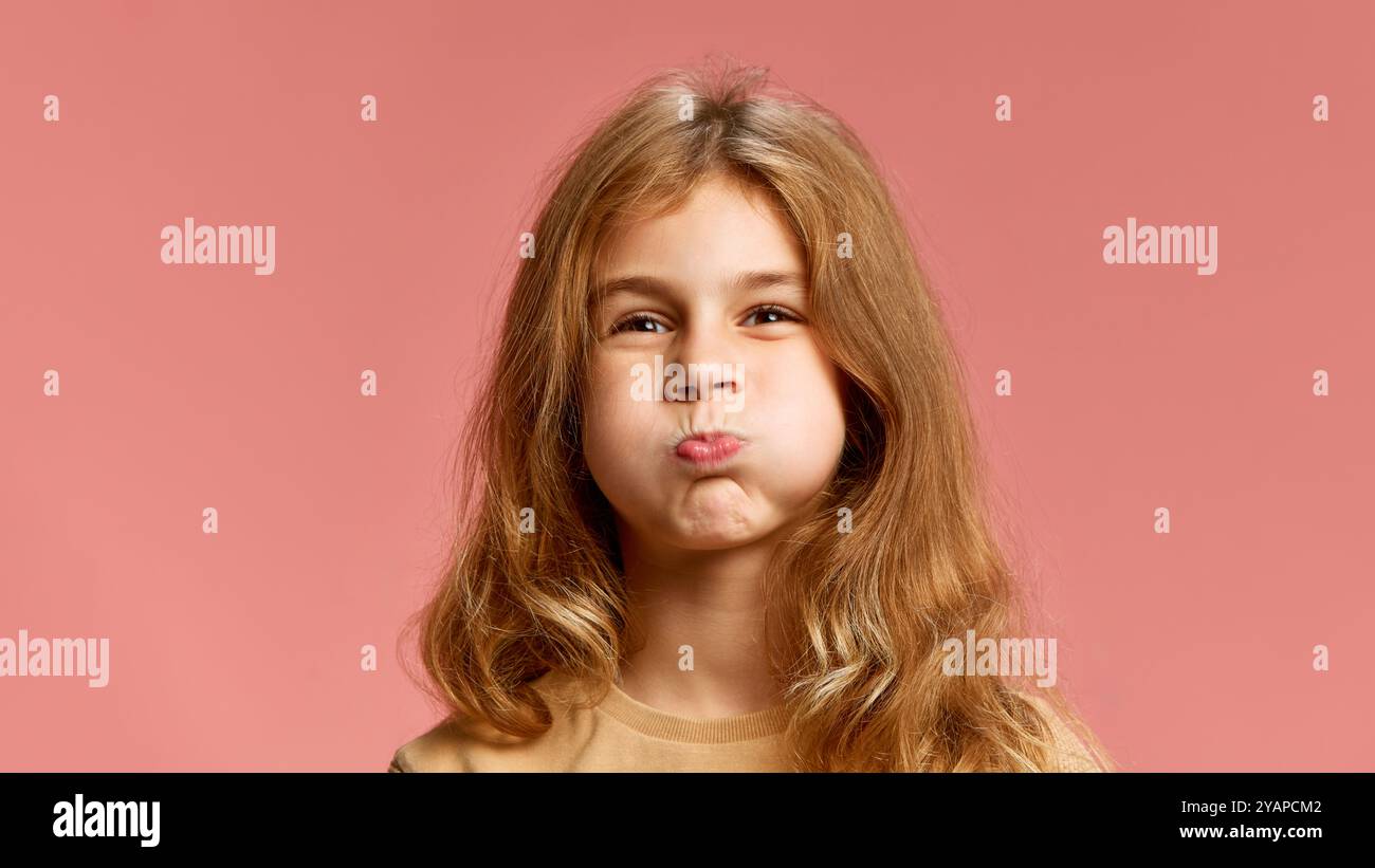 Girl's cheeks puffed out of frustration or stubbornness, adding ...