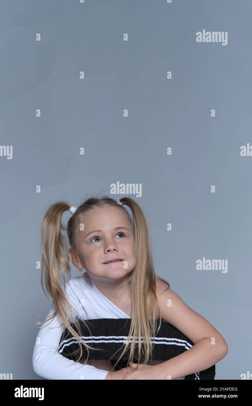 A thoughtful child with a subtle smile, her playful hairstyle adding to ...