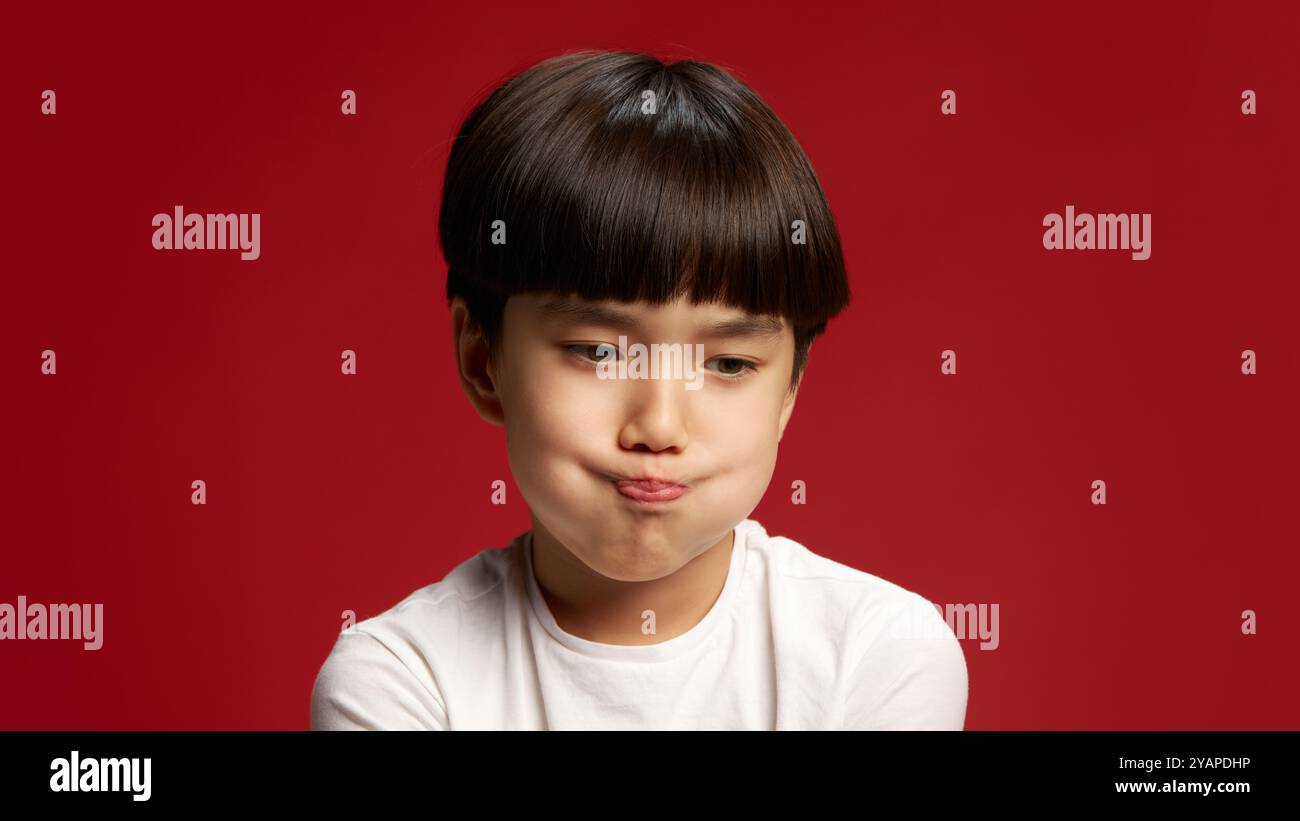 Child's cheeks puffed out in playful manner, showcasing lighthearted ...