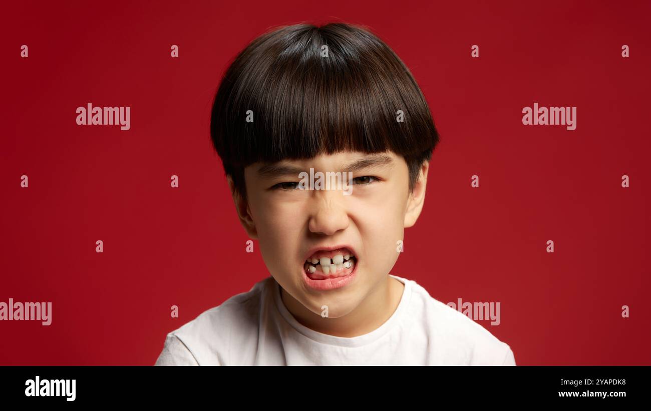 Child displays fierce, energetic expression, teeth showing in moment of ...