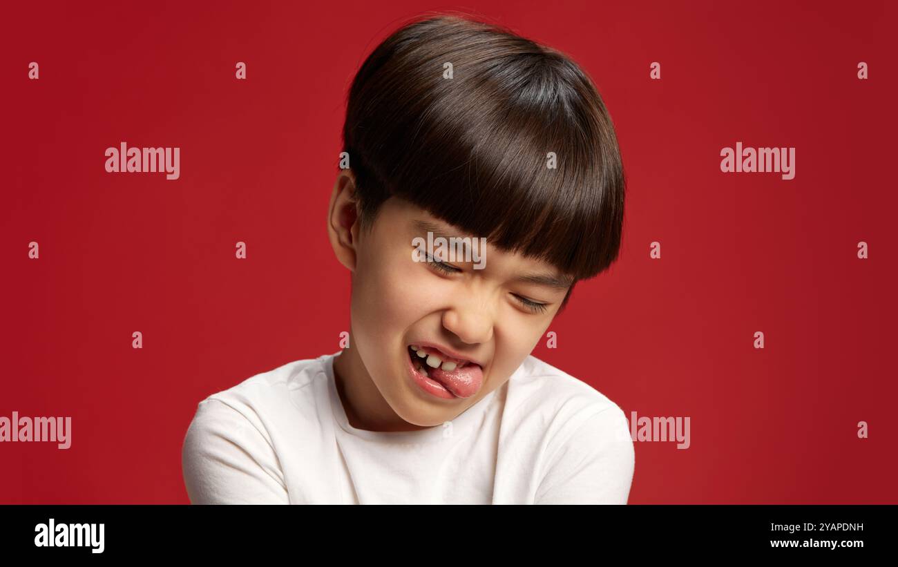 Little boy, Asian child playfully scrunching his face with eyes closed ...