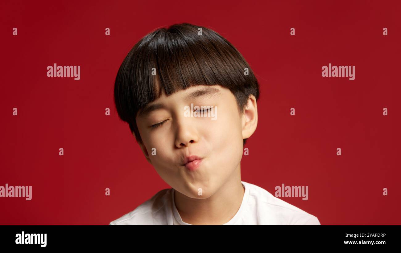 Little child, Asian boy puckering their lips as if giving kiss, with ...