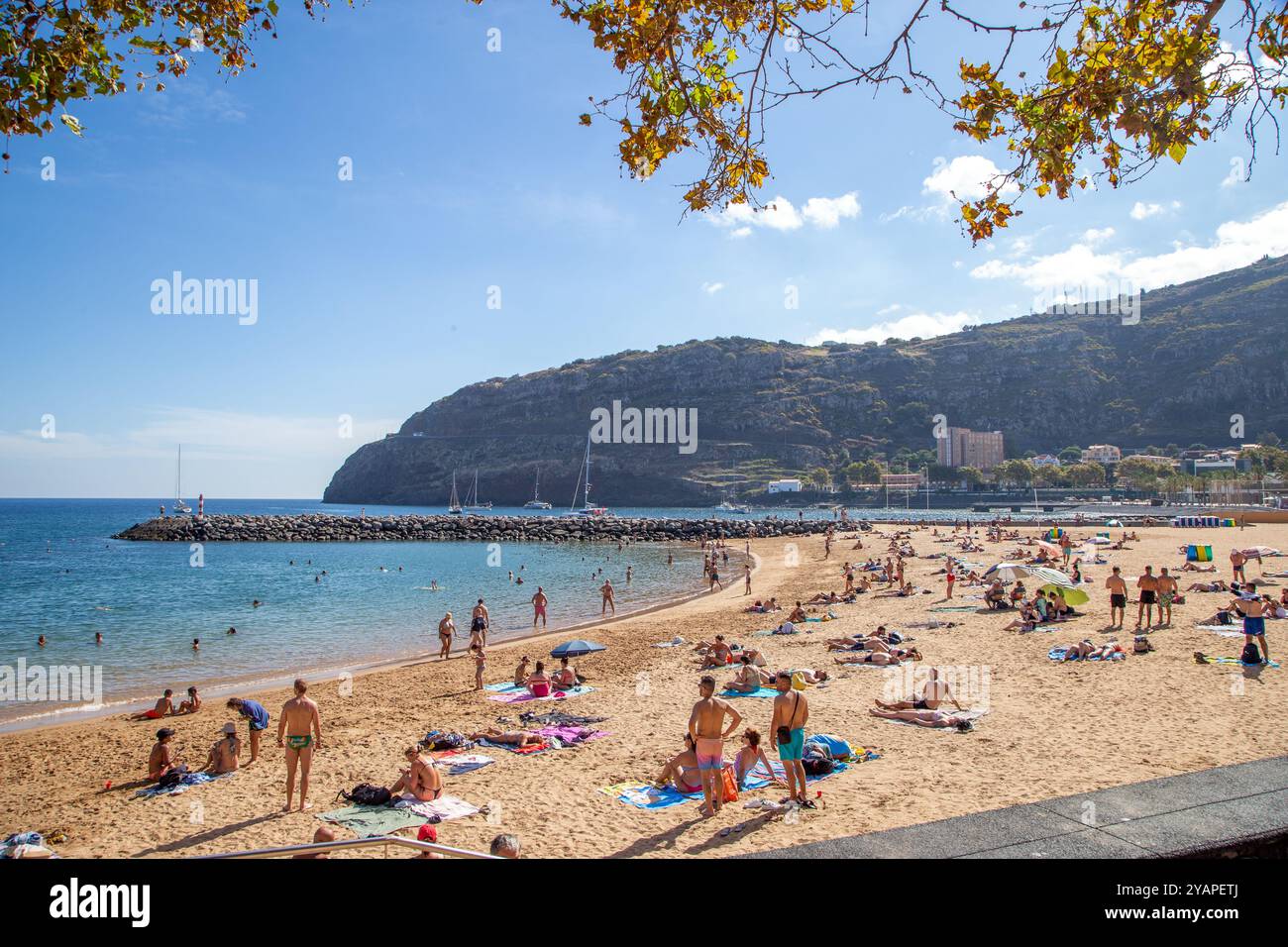 Holidaymakers and people sunbathing on vacation on the man made beach ...