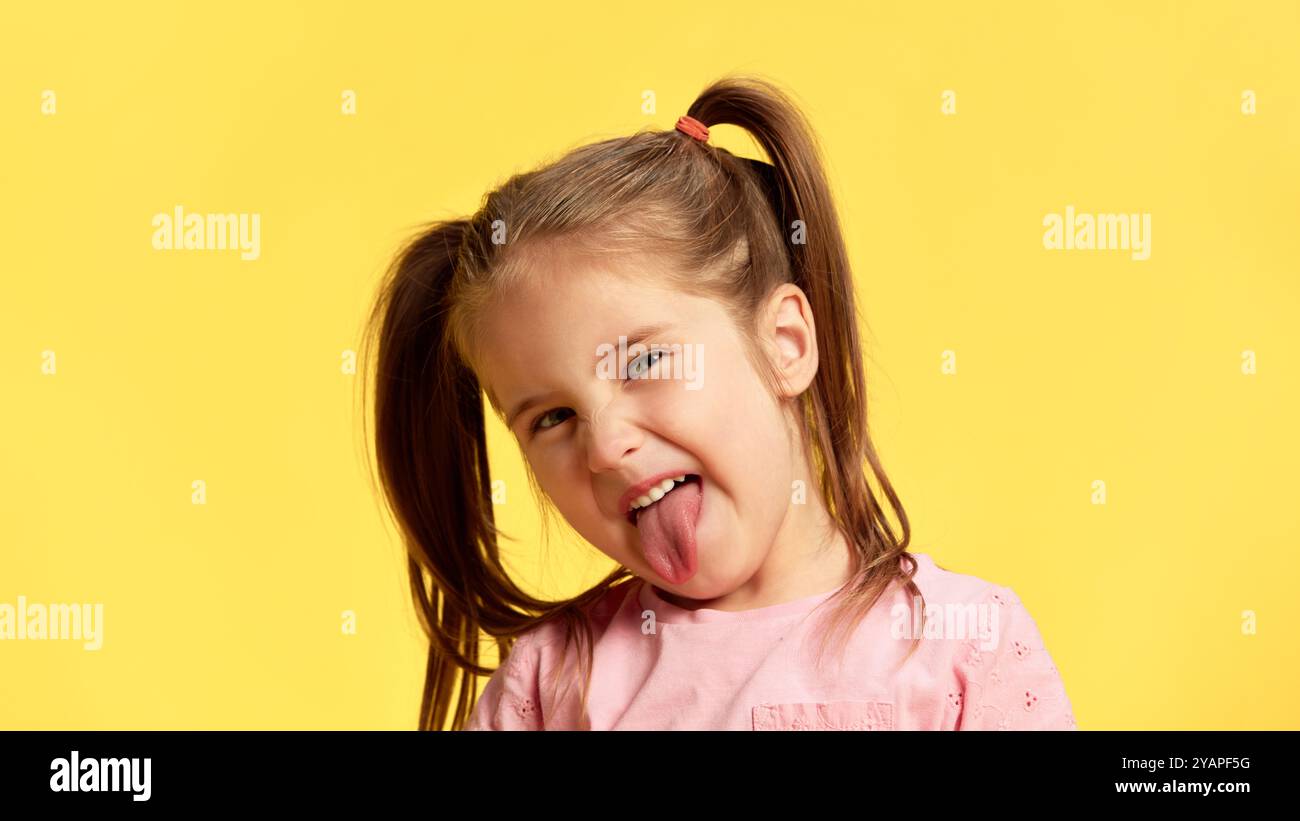 Sticking out her tongue playfully, girl shows off her mischievous side ...