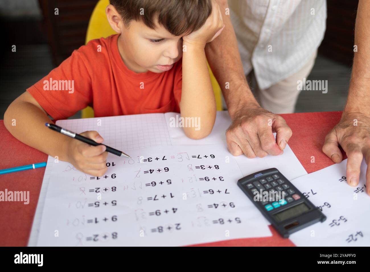 A boy with dysgraphia and dyscalculia struggles with his math homework ...