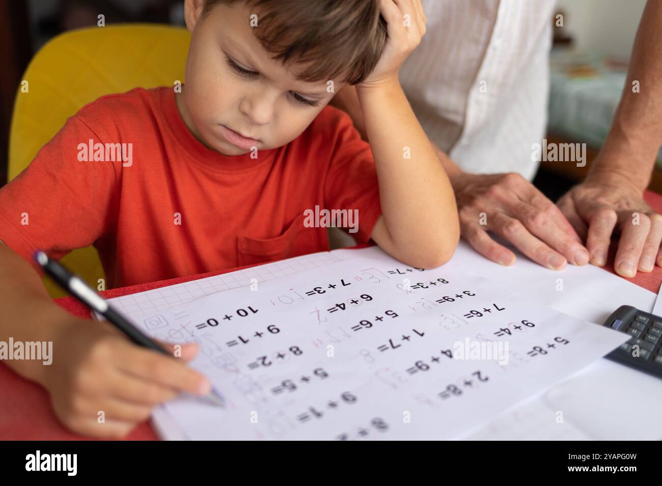 A boy with dyscalculia and dysgraphia tries to complete his math ...