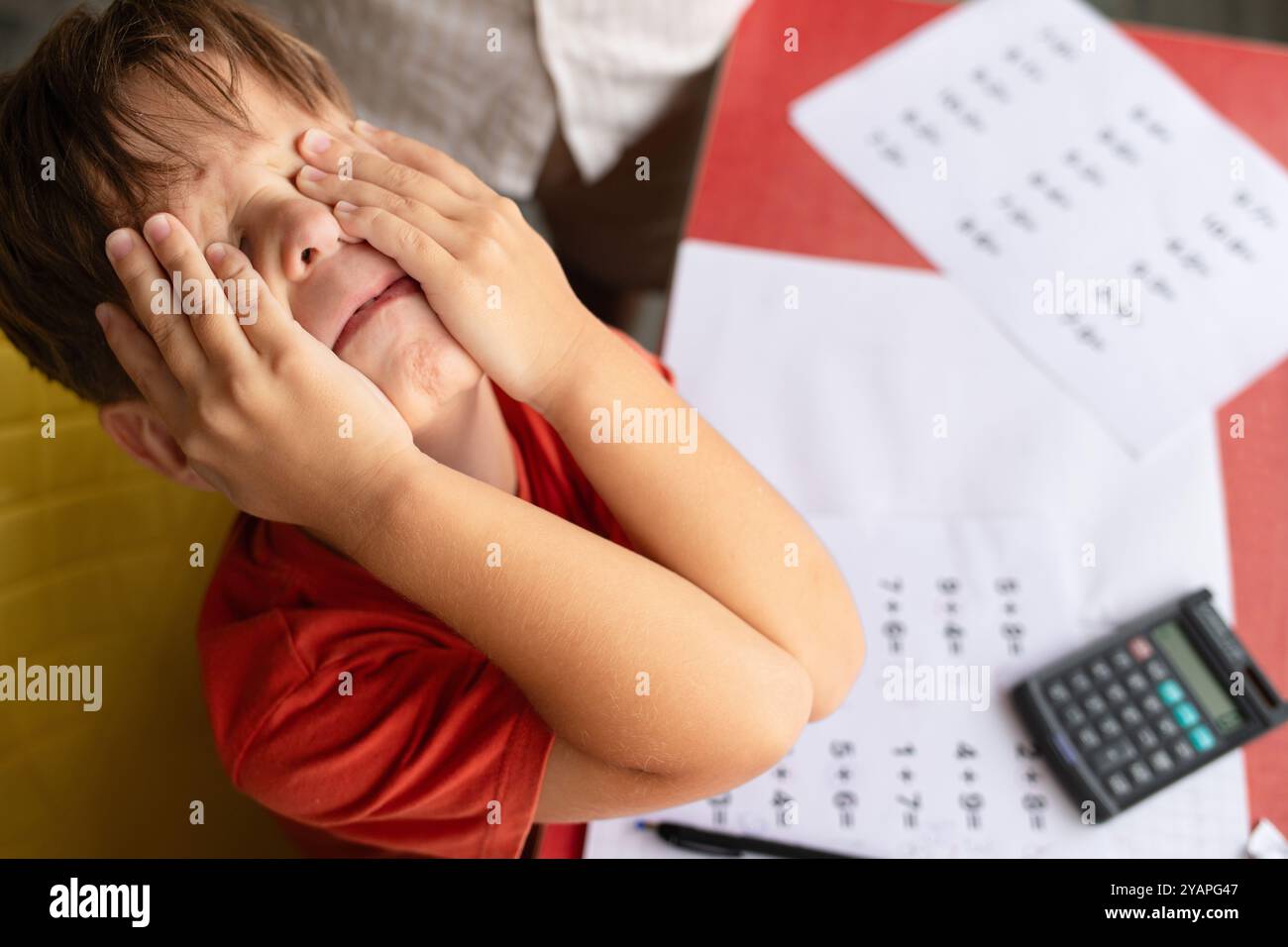 A child with dyscalculia and dyslexia is on the verge of tears while ...
