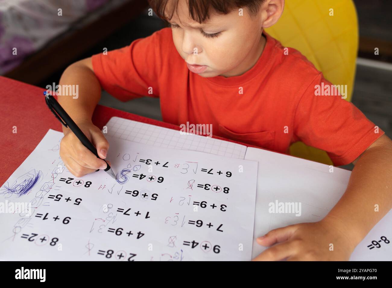 A boy with dyscalculia and dysgraphia tries to complete his math ...