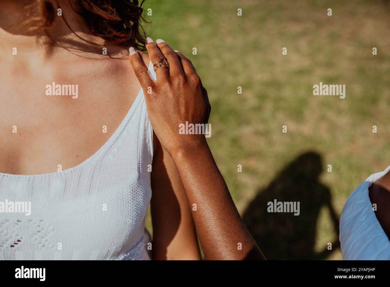 An African woman is touching the shoulder of her Caucasian friend ...