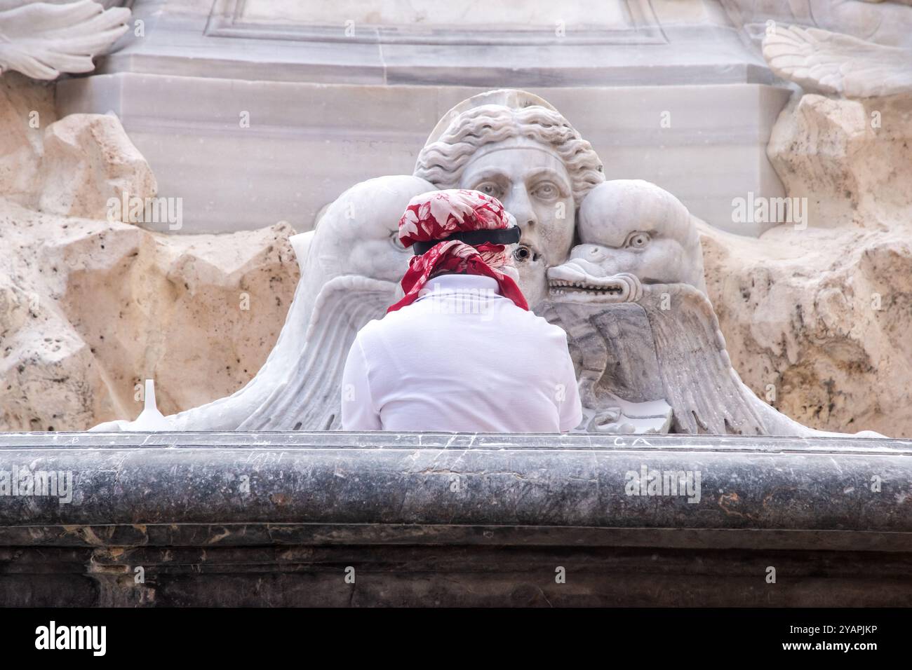 A restoration worker works on cleaning the marble statues from the ...