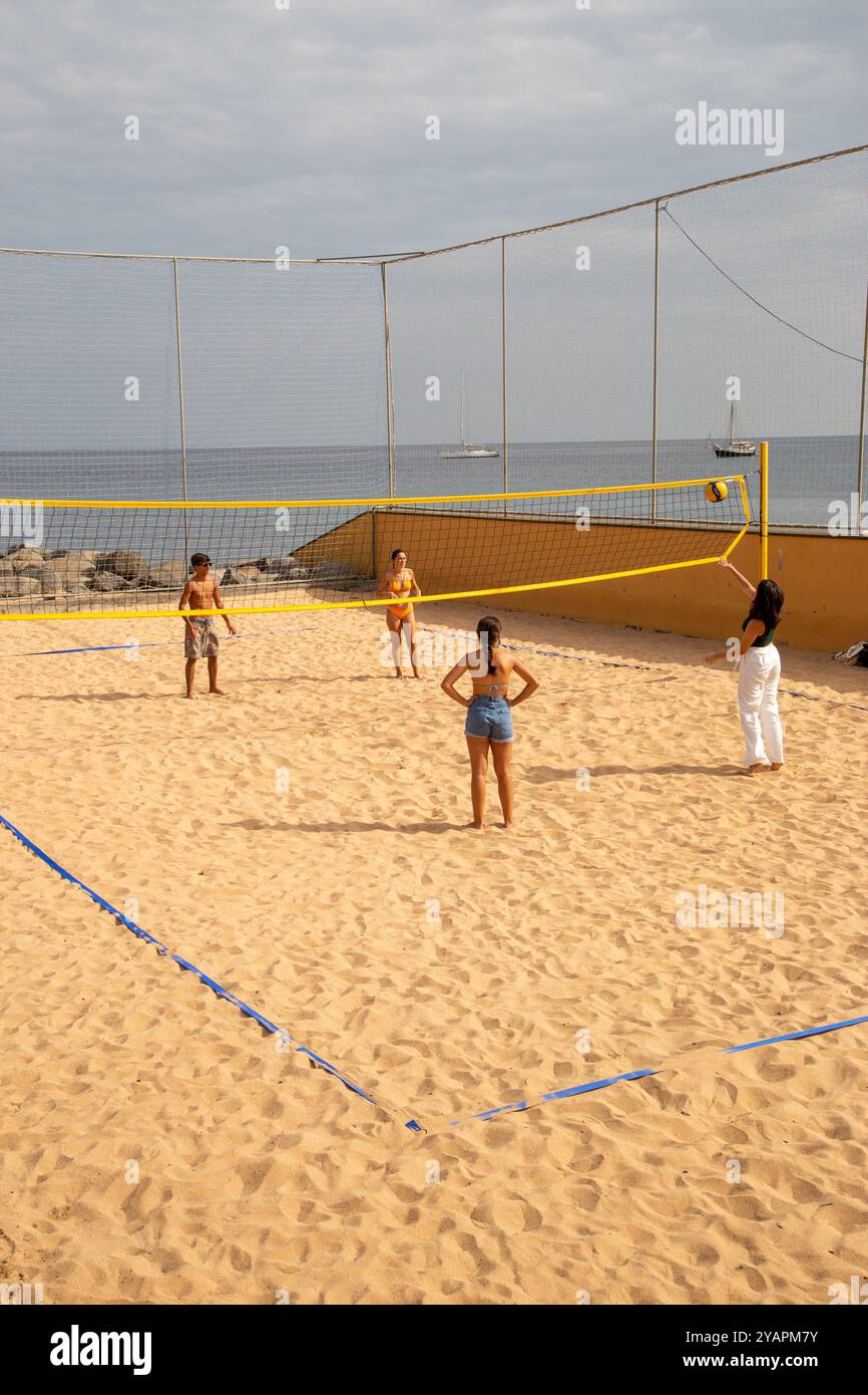 Young people playing beach volleyball at the seaside resort of Machico ...