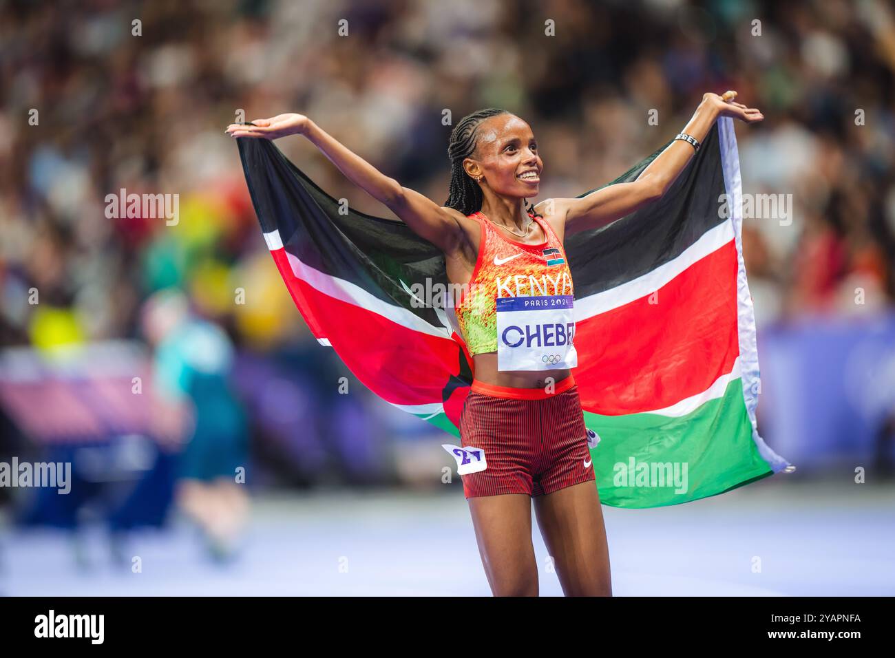 Beatrice Chebet celebrating her victory with her country's flag in the ...