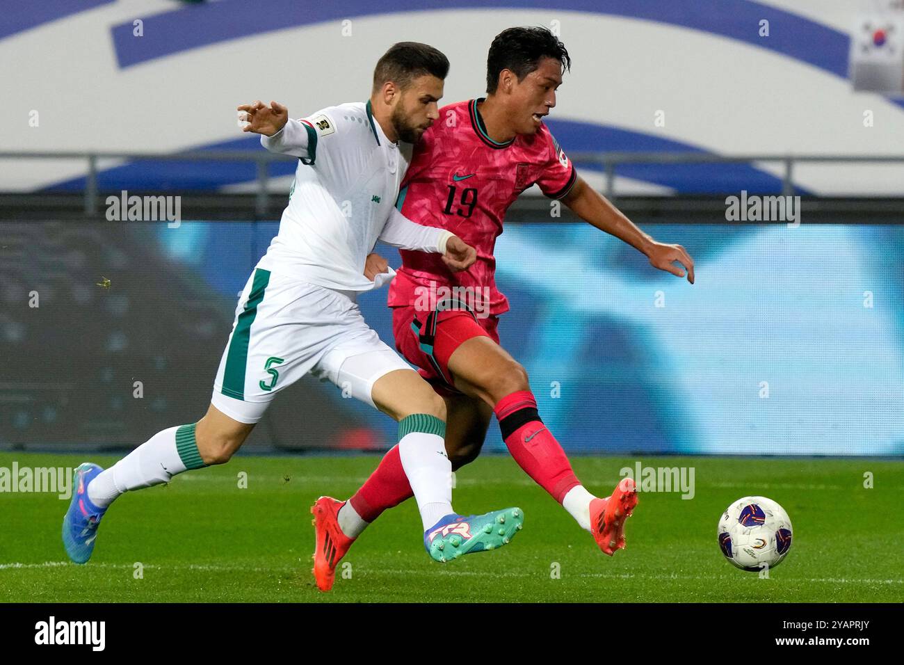 South Korea's Oh Se-hun, right, fights for the ball with Iraq's Ahmed ...