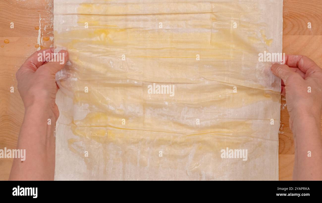 Brush each layer of phyllo dough with melted butter, step by step ...