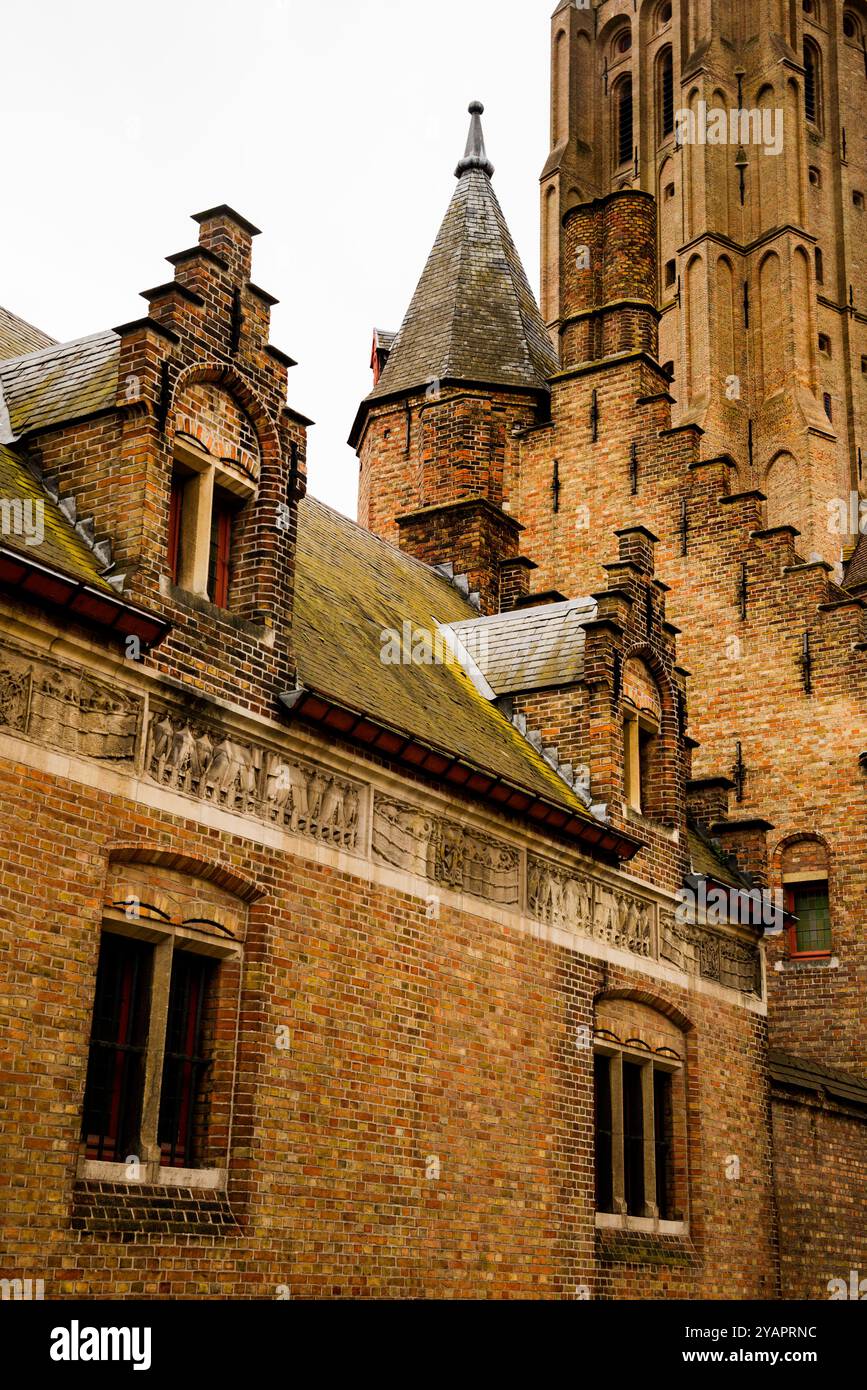 Pointed arch brick window pediments and a carved stone frieze in Bruges ...