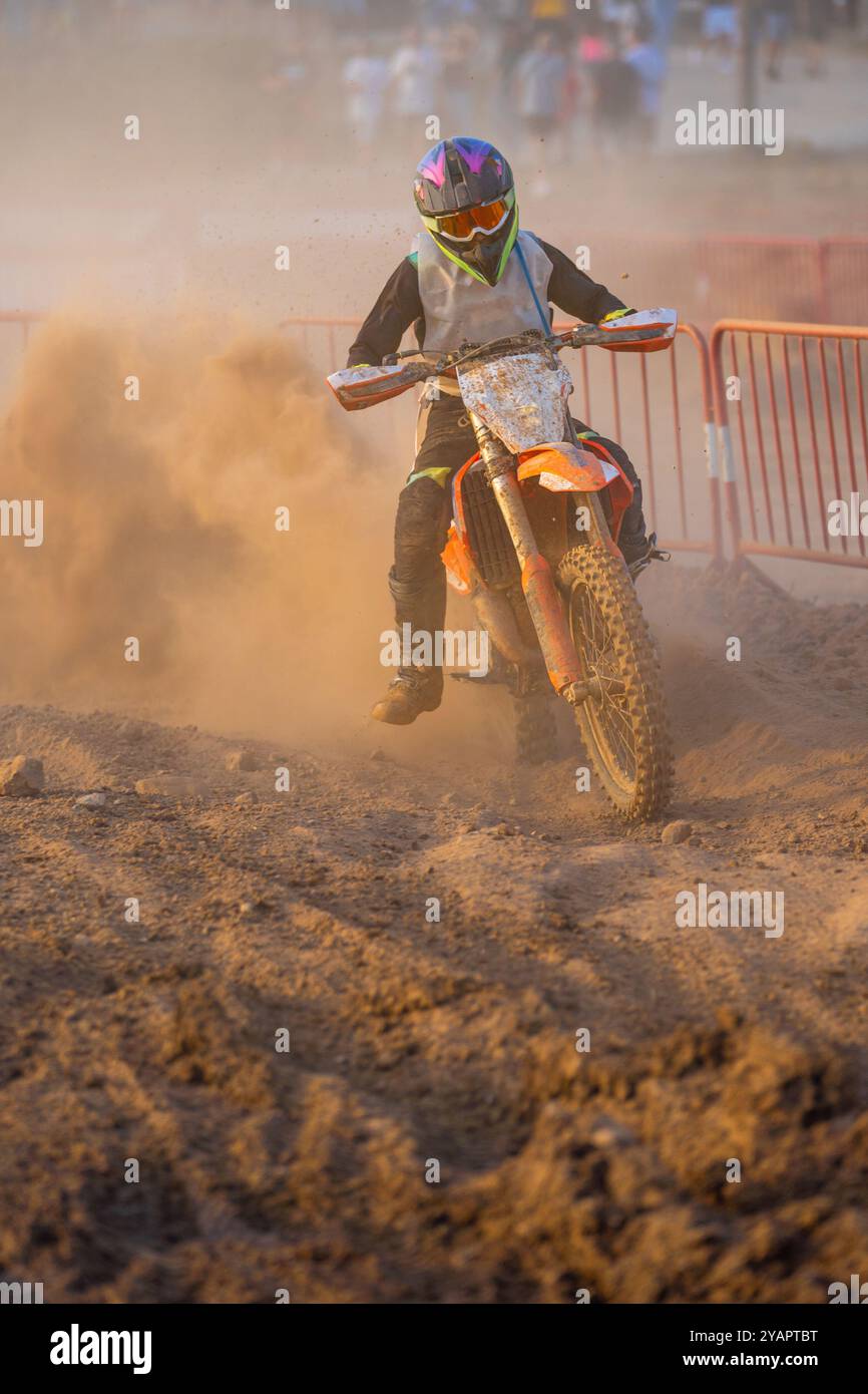 Motocross rider in action racing down a dirt road creating a lot of ...