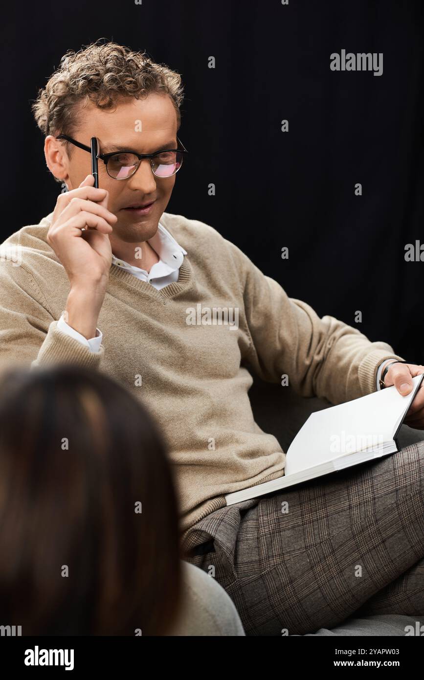 A journalist attentively interviews a professional woman, taking notes ...