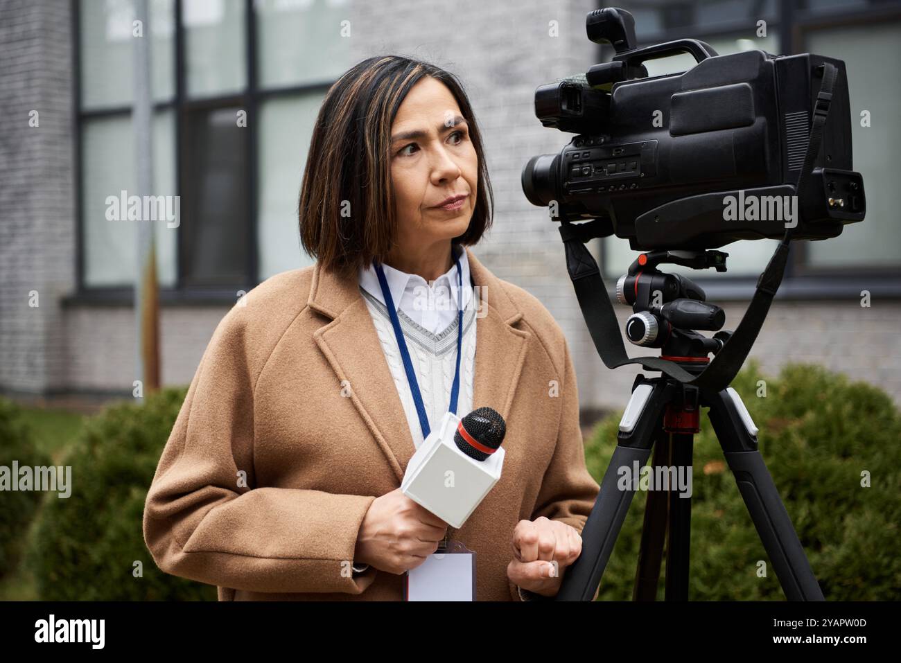 A dedicated journalist prepares for an interview, microphone in hand ...