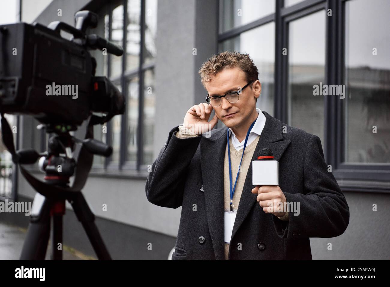 A dedicated journalist holds a microphone, preparing for an important ...