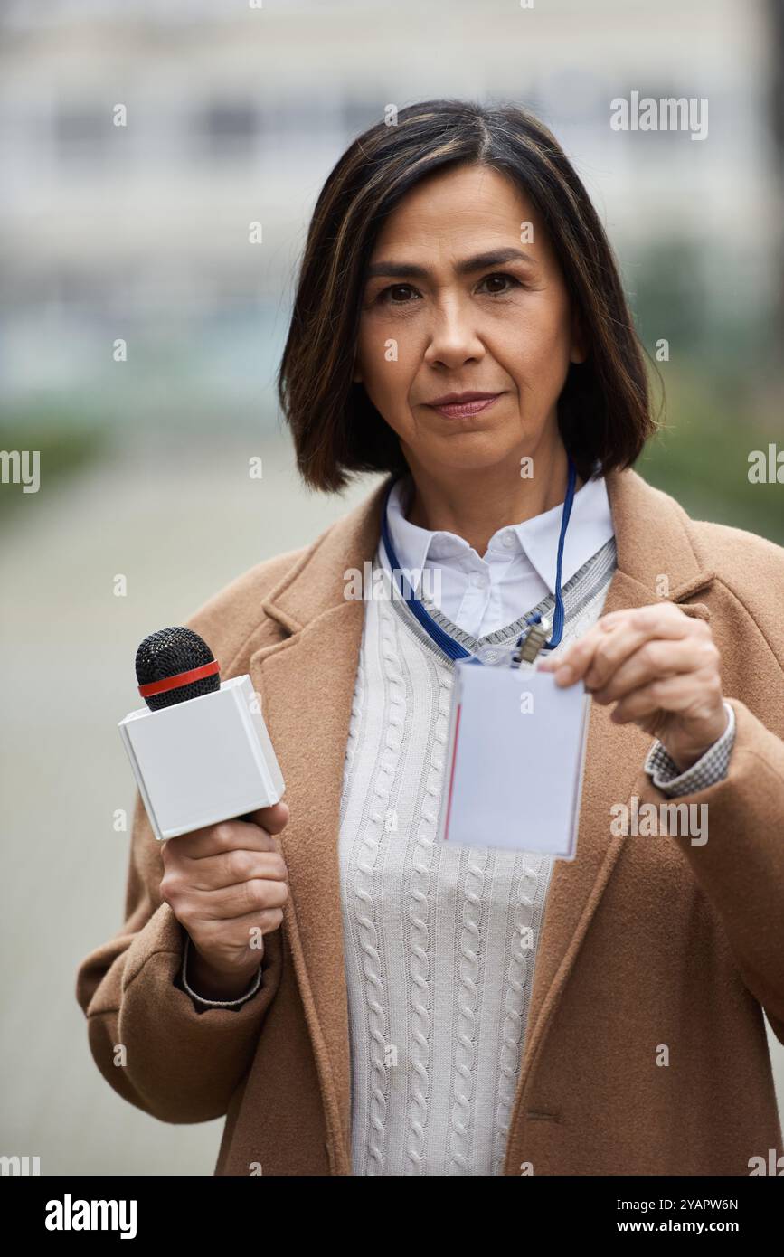 A multiracial female journalist confidently holds a microphone and ...