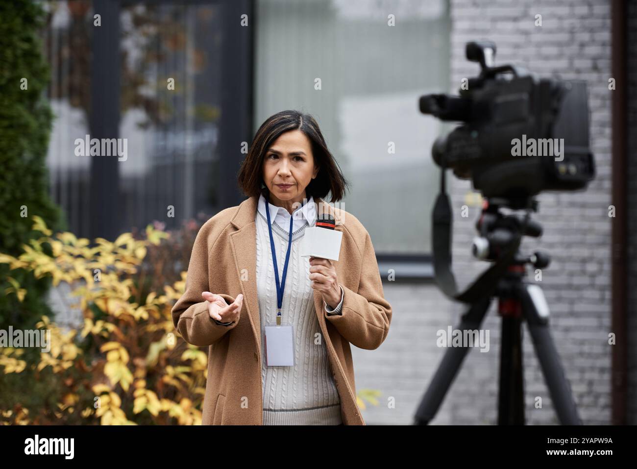 A multiracial female journalist speaks into a microphone, capturing the ...