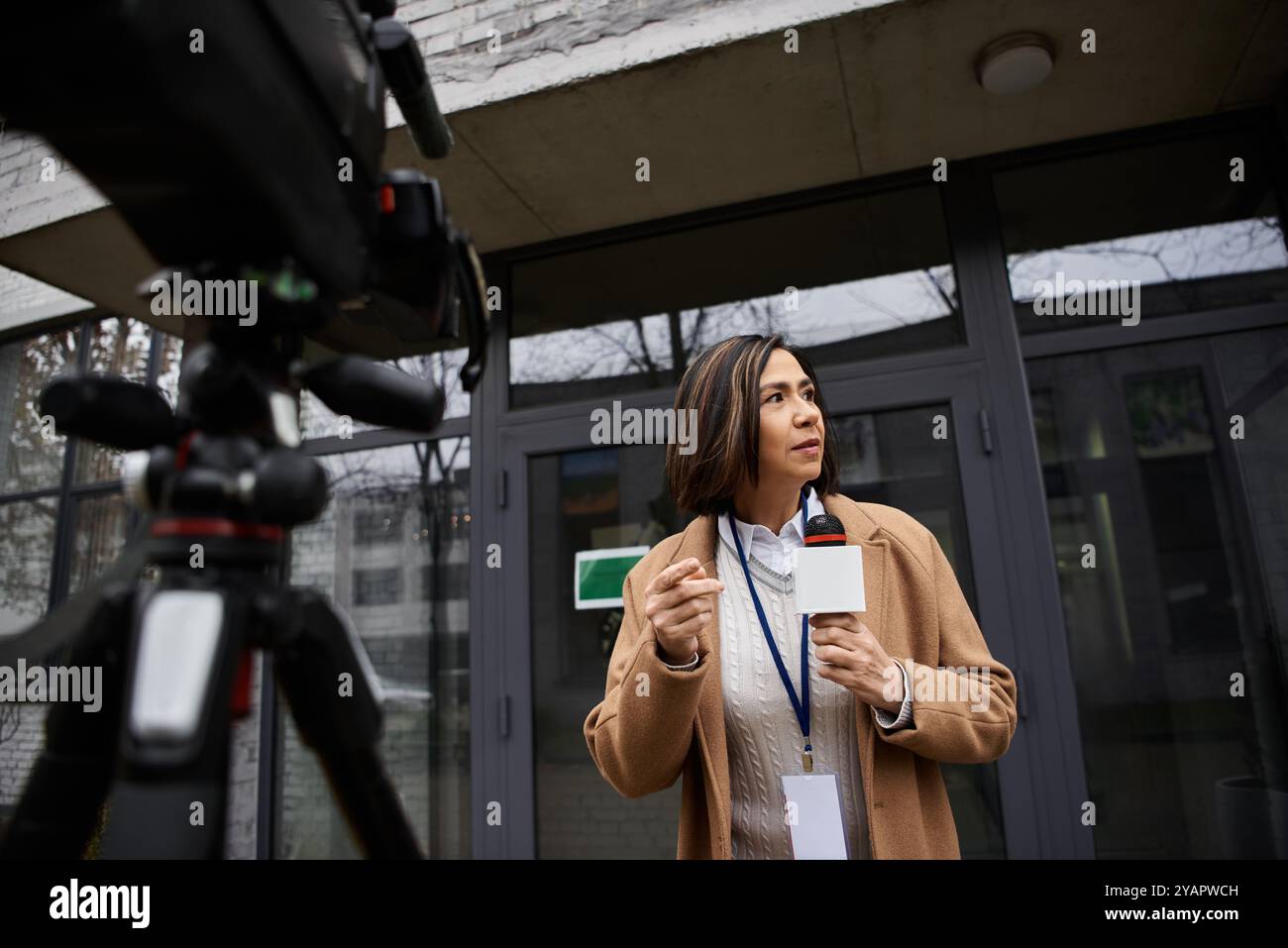 The journalist stands confidently with a microphone, ready to deliver ...