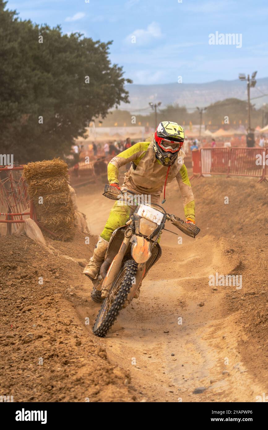 Motocross rider in action preparing to take a sharp turn on dusty ...
