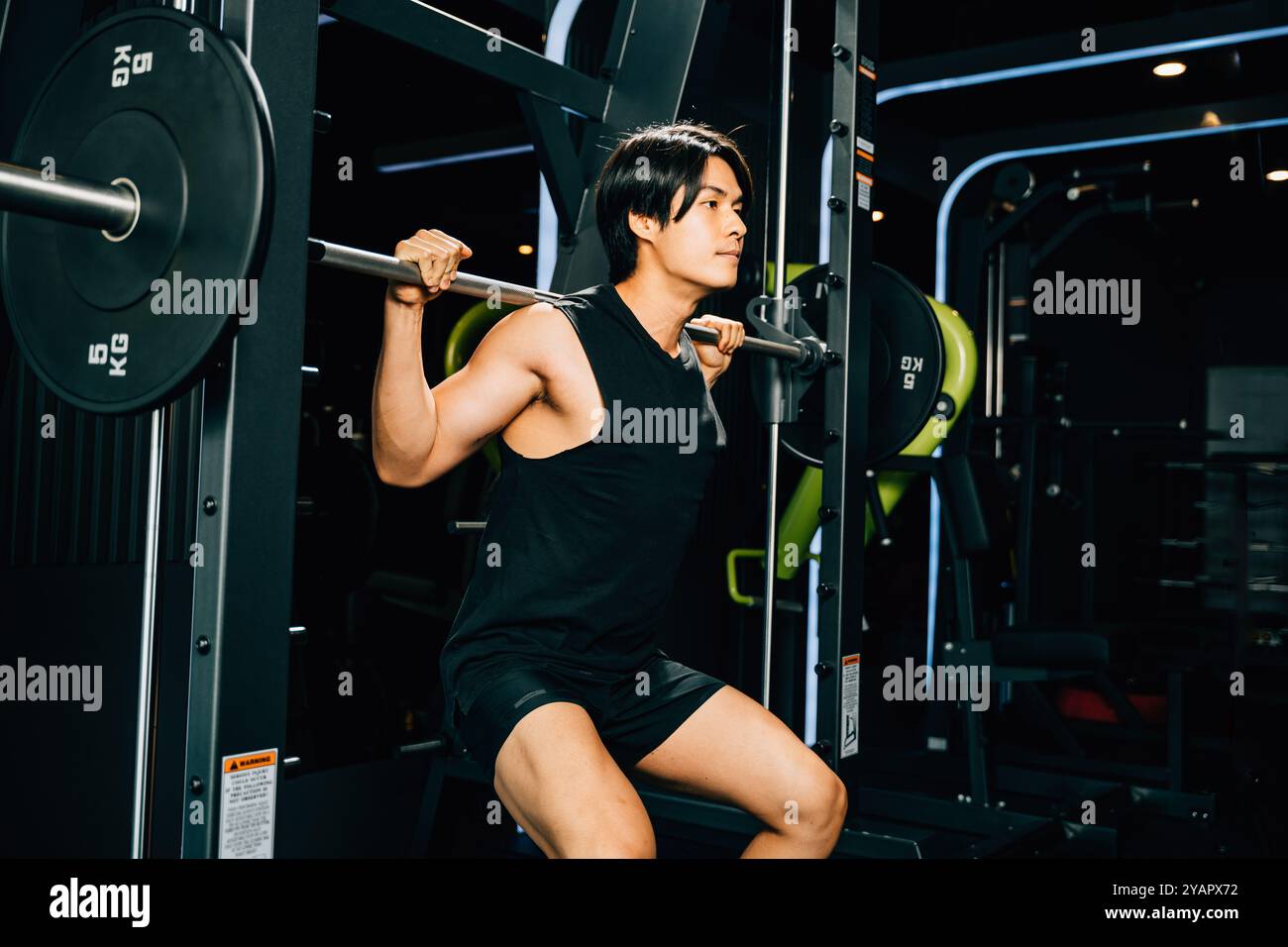 Asian muscular man guy performing a squat exercise legs heavy weights ...