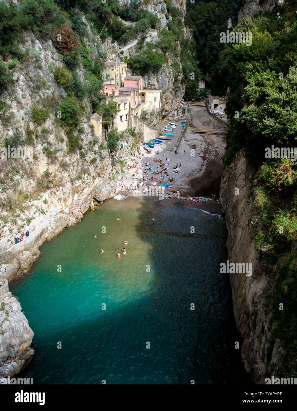 Visitors enjoy the serene waters of a secluded beach on the Amalfi ...