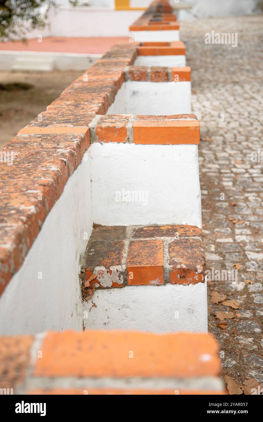 Close-up of a brick balustrade set against white painted cement ...