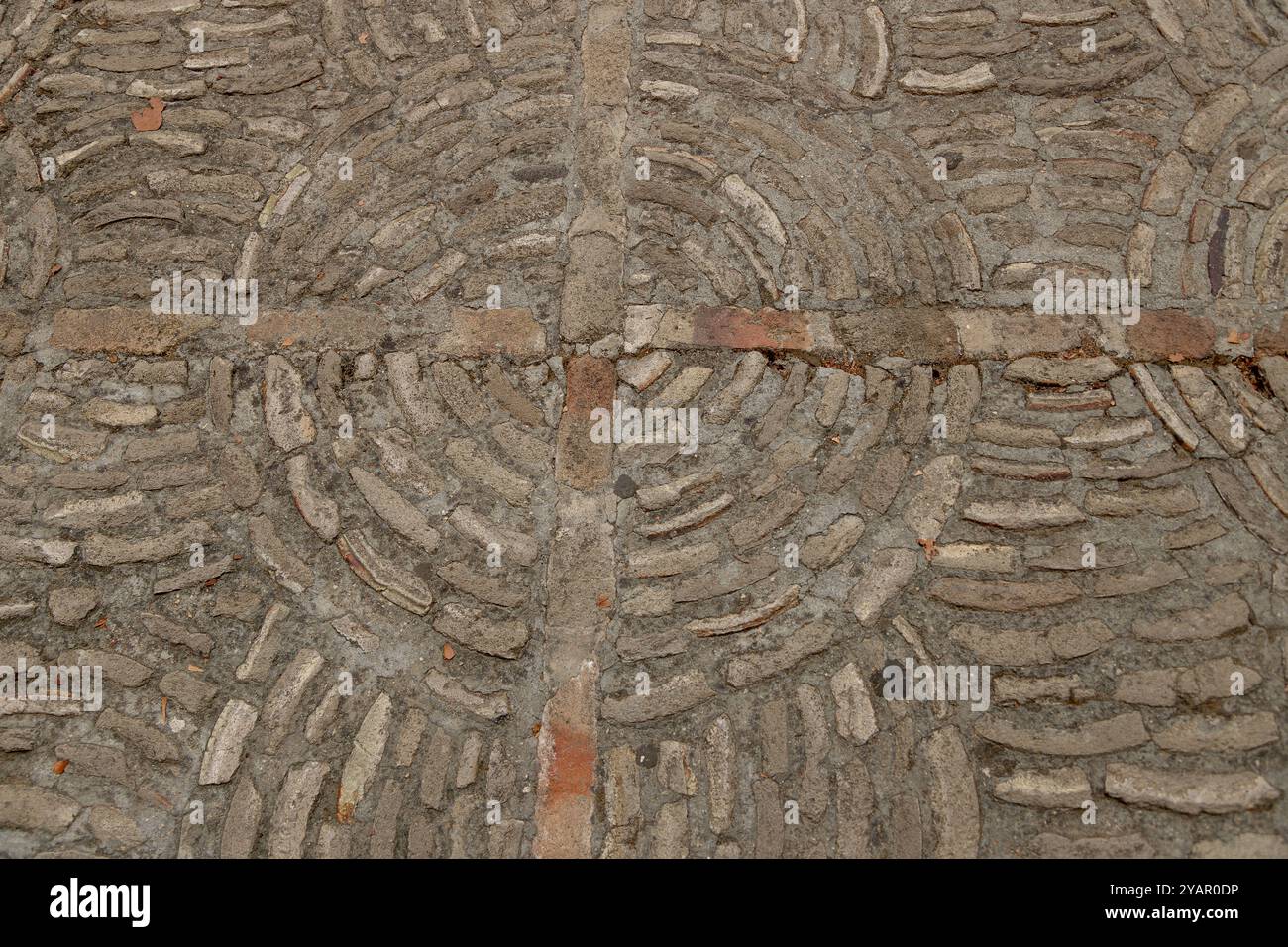 Close-up of a stone pavement featuring a circular brick pattern ...