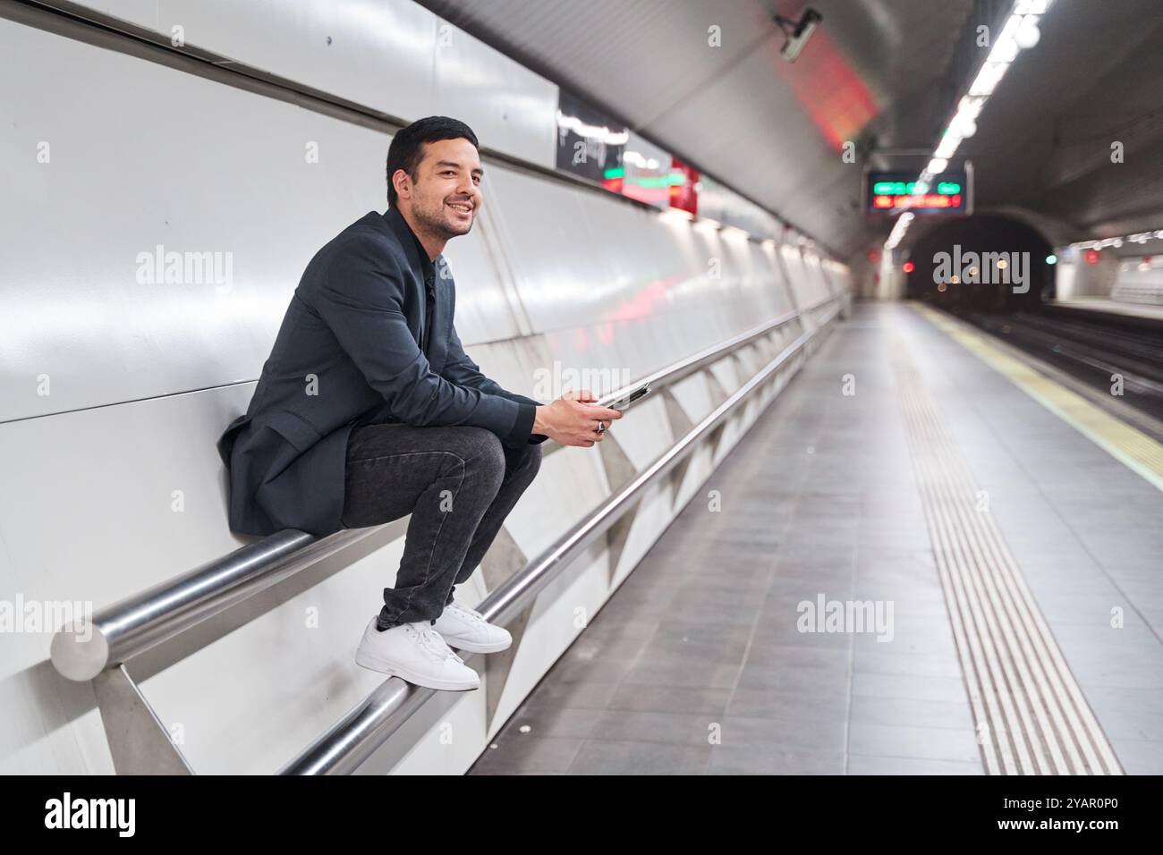 man sitting in station waiting for metro Stock Photo - Alamy