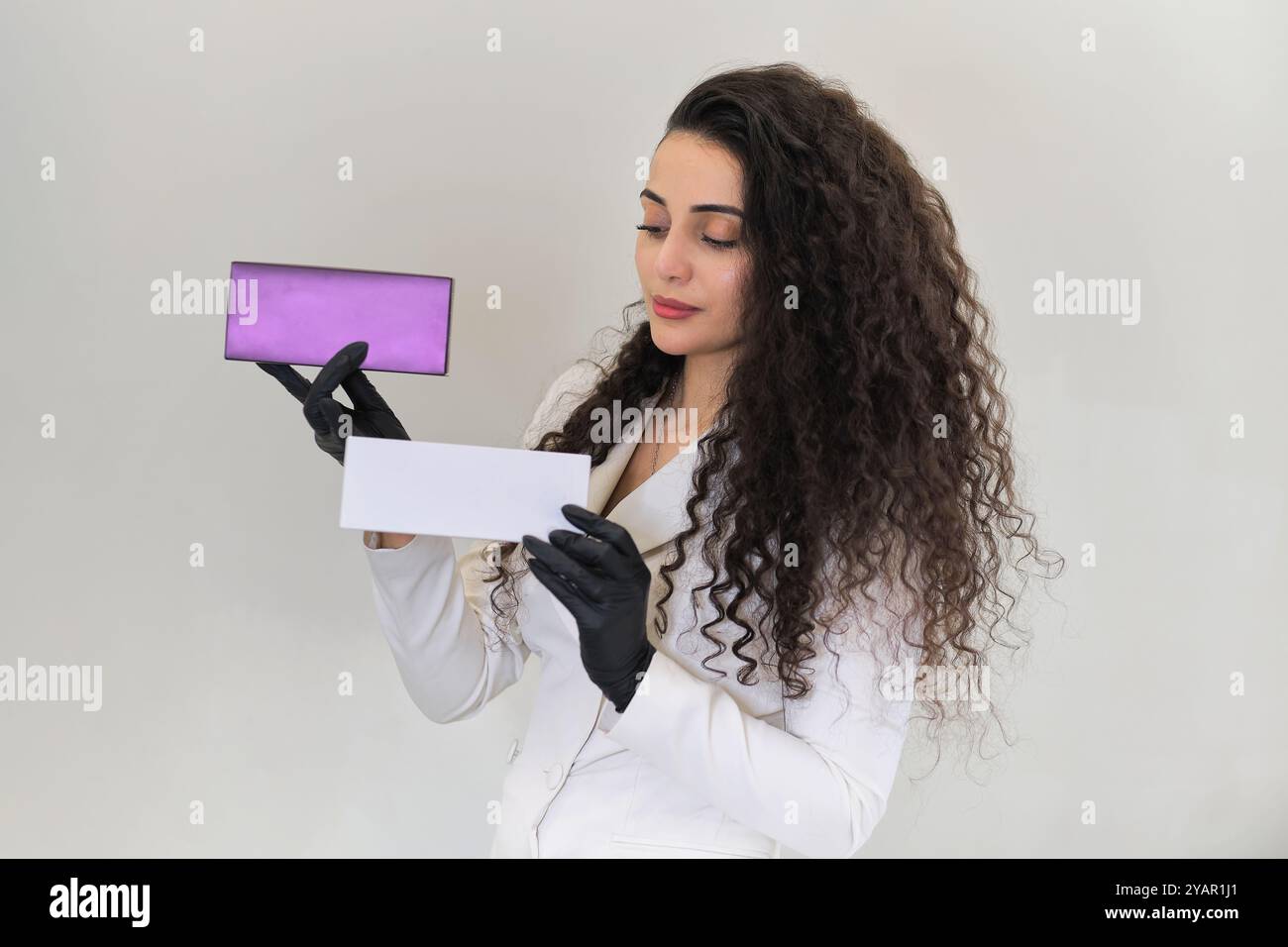 Cosmetologist holds boxes of injectables, ready for a cosmetic procedure. tools of ...