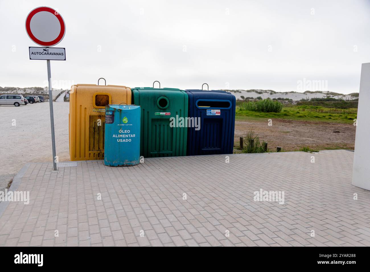 A set of colorful recycling bins, including containers for glass, paper ...