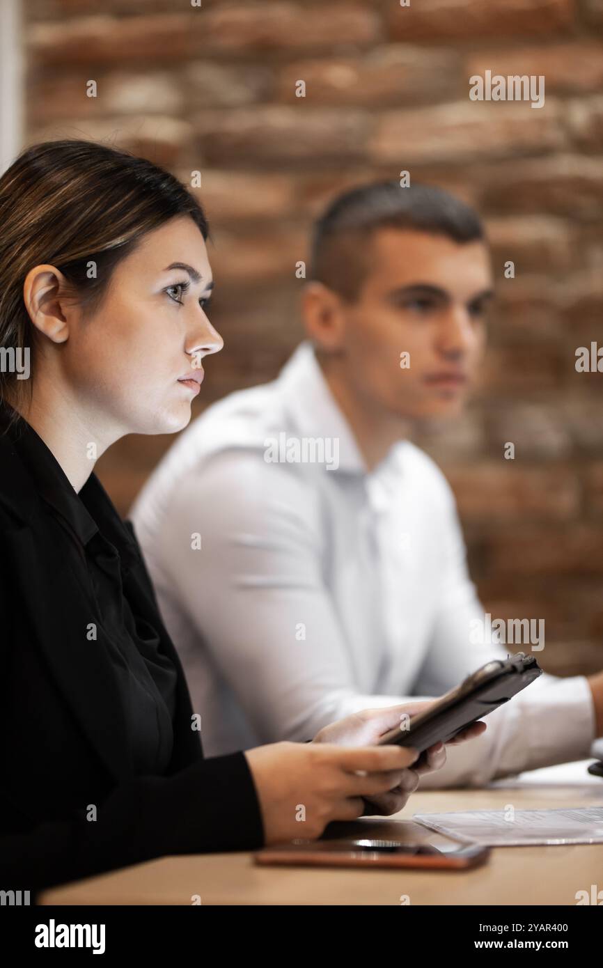 Two young professionals, a man and a woman, engage intently in a ...