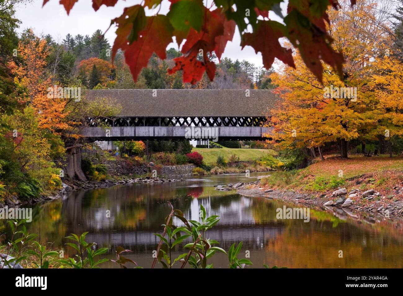 Trees changing to Autumn colors surround the Middle Covered Bridge ...
