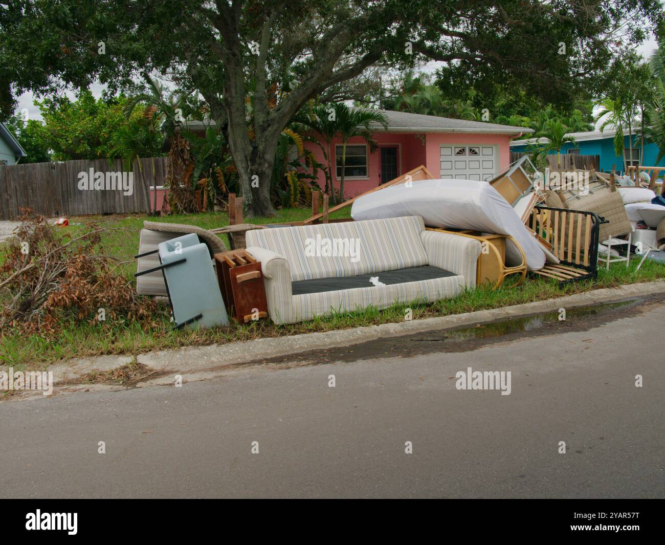 Large piles of trash, furniture, household items stacked on side of a ...