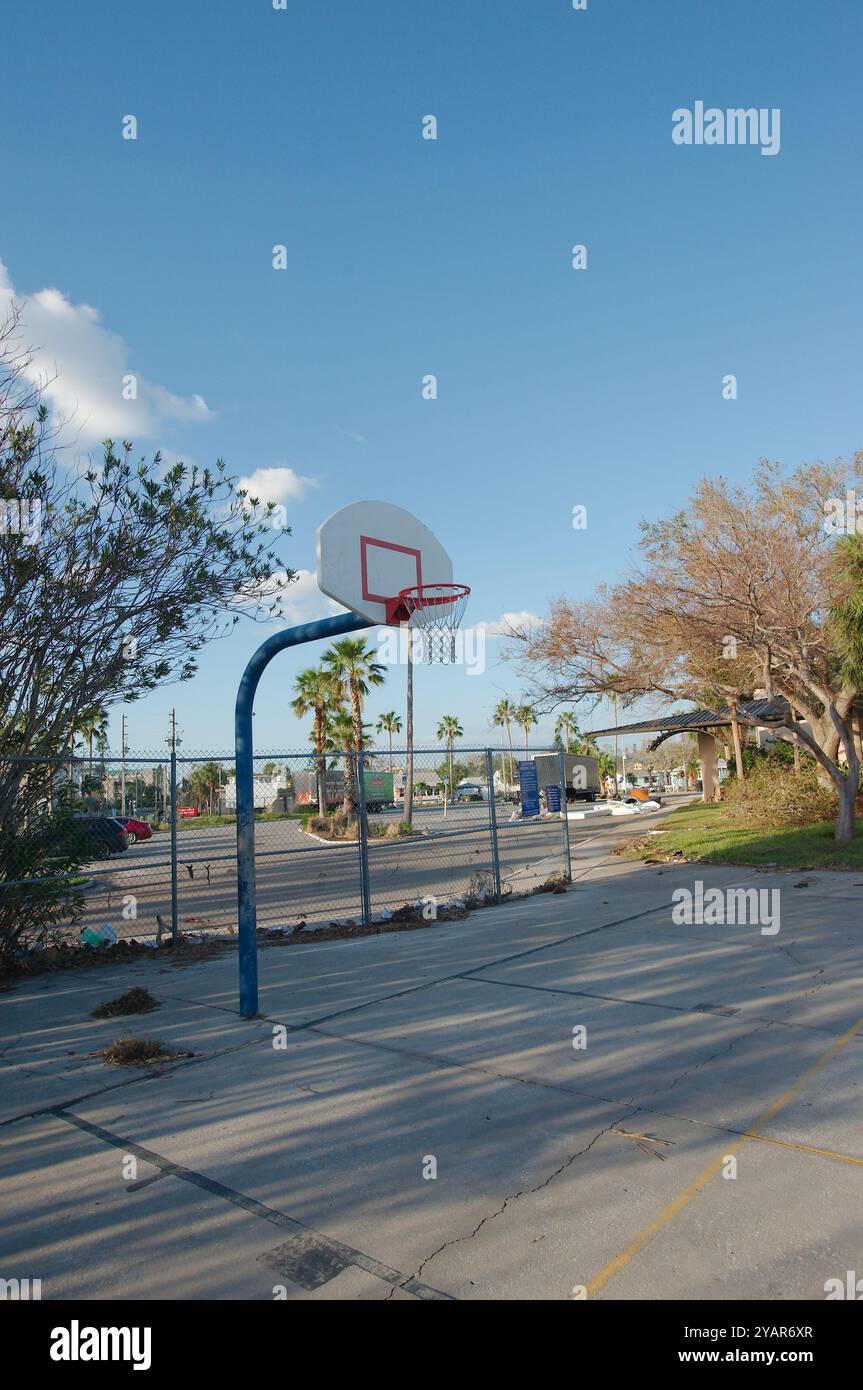 Outdoor white metal basketball backboard court with cracks in pavement ...