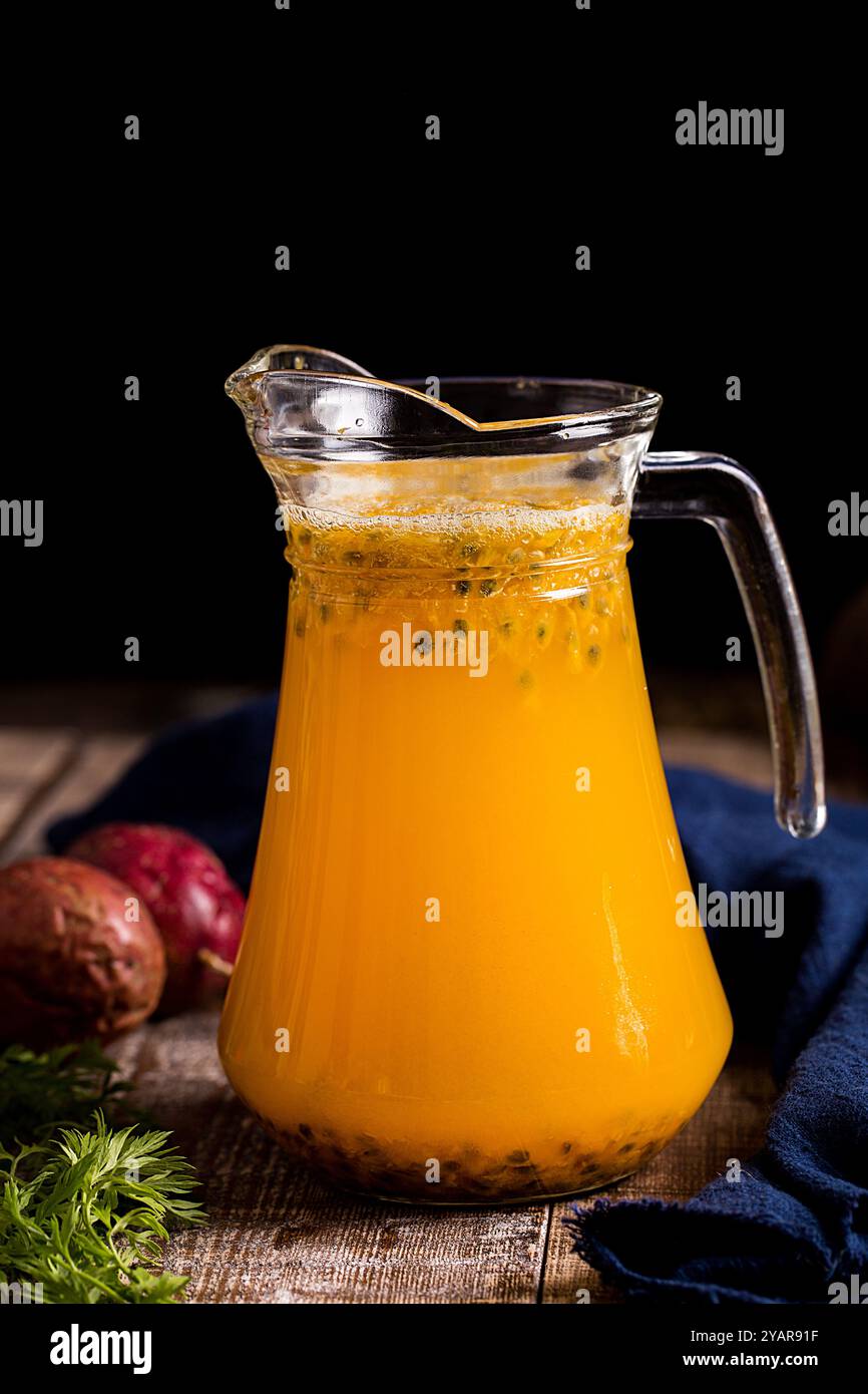 Closeup passion fruit (maracuya) juice with passion fruit half slice in tall glass. Healthy ...