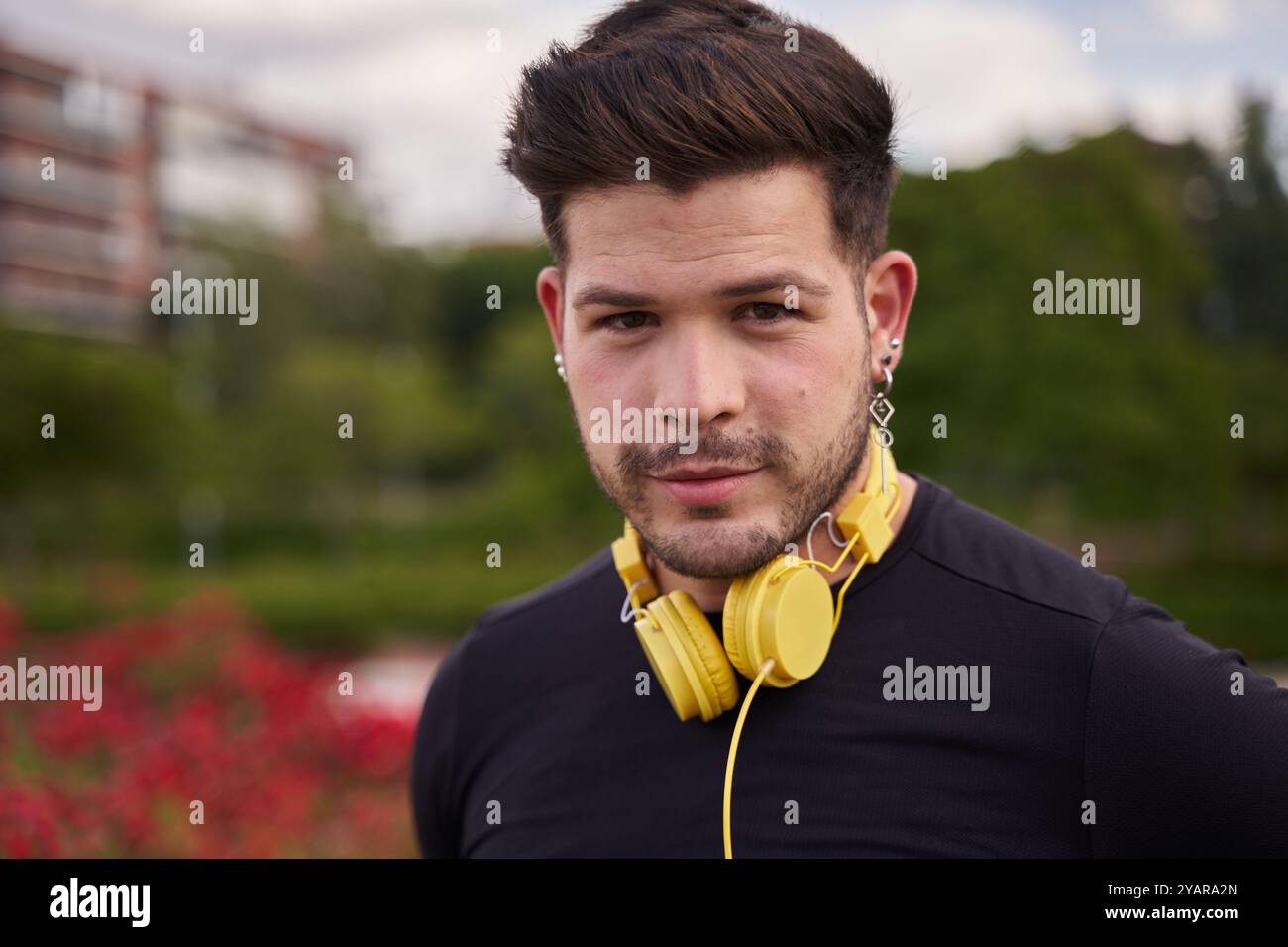 portrait of a latin man looking at the camera with yellow helmets ...