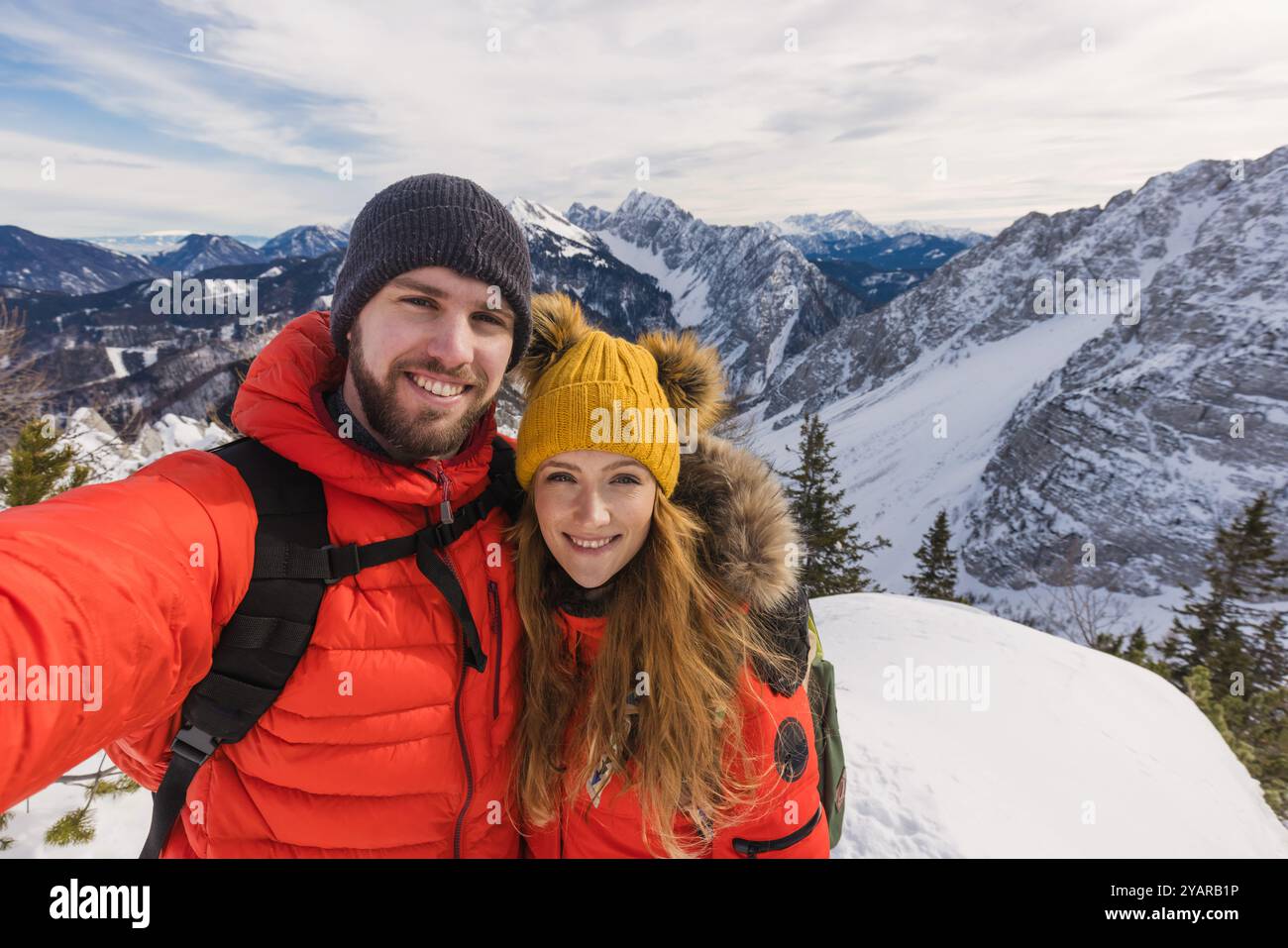 Climbing couple takes a selfie from a snowy landscape in the winter ...