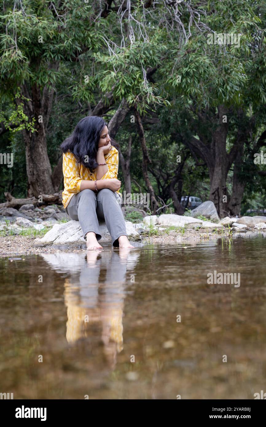 Isolated Girl Sitting Alone on Stone at Calm Lake Shore in the Morning ...