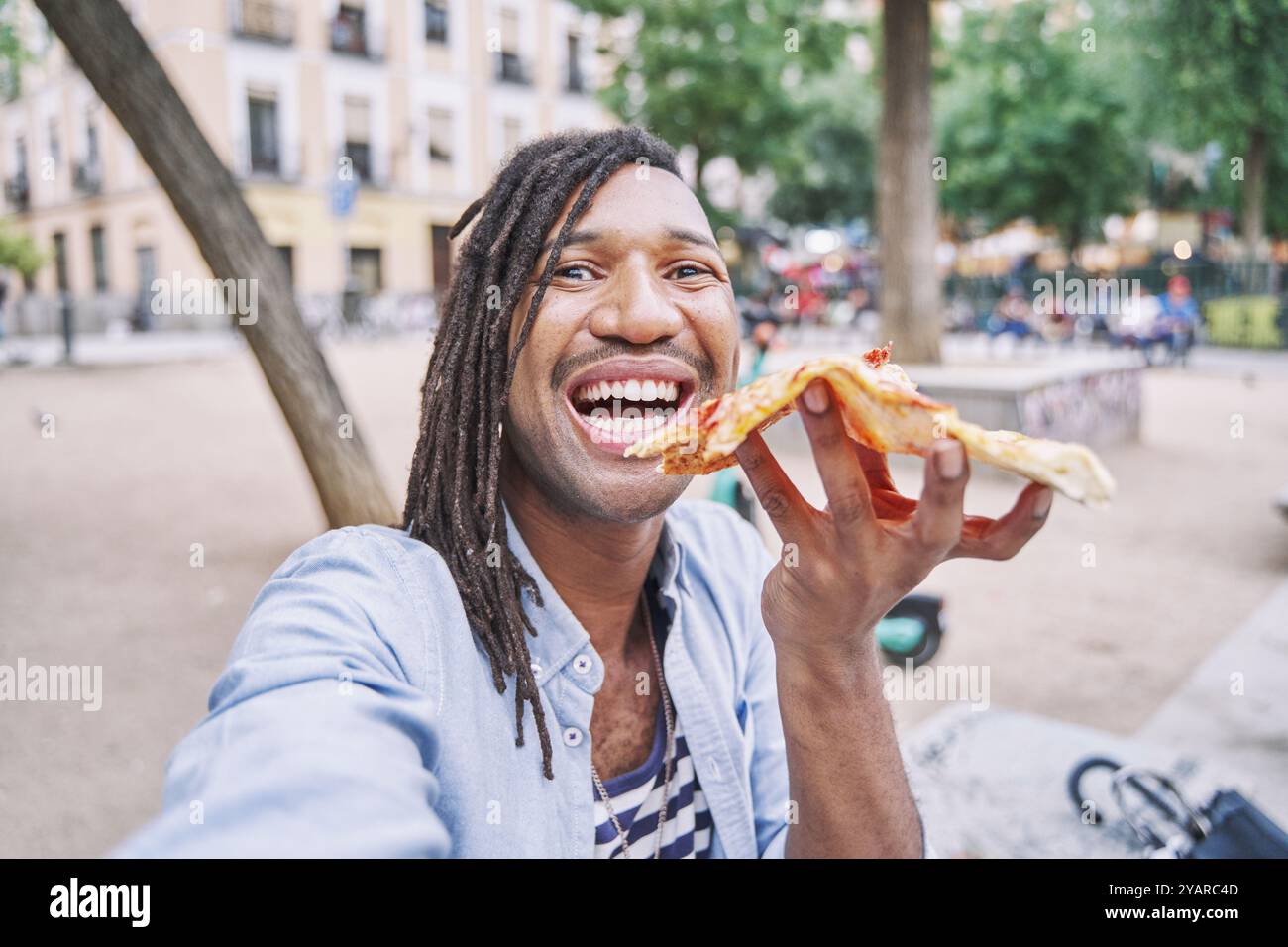 Excited man making selfie while eating pizza. Laughing man with ...